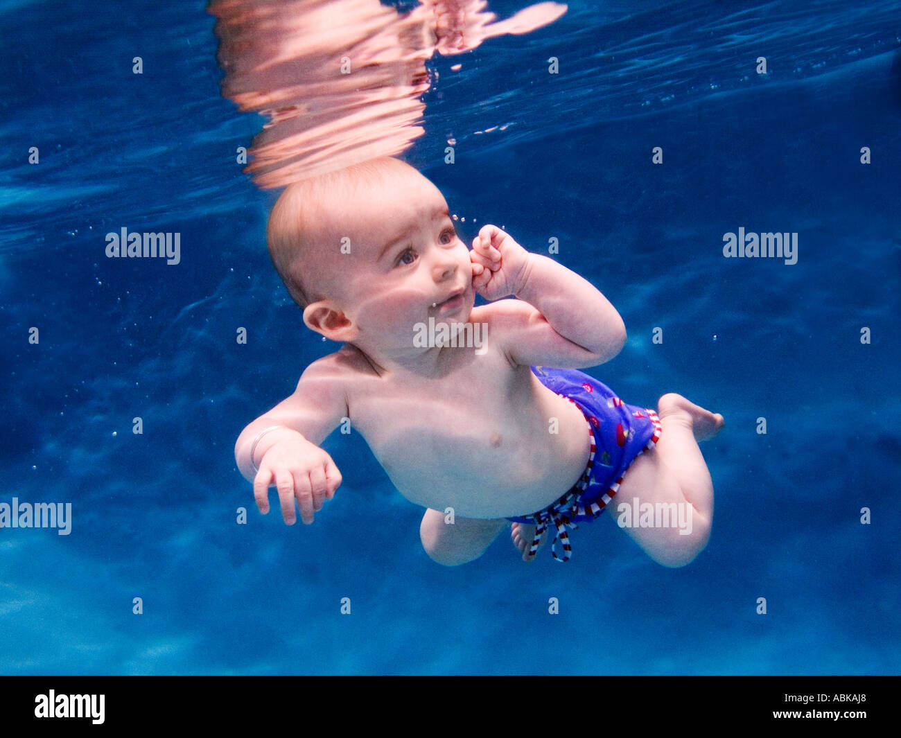baby swimming underwater blue background Stock Photo - Alamy