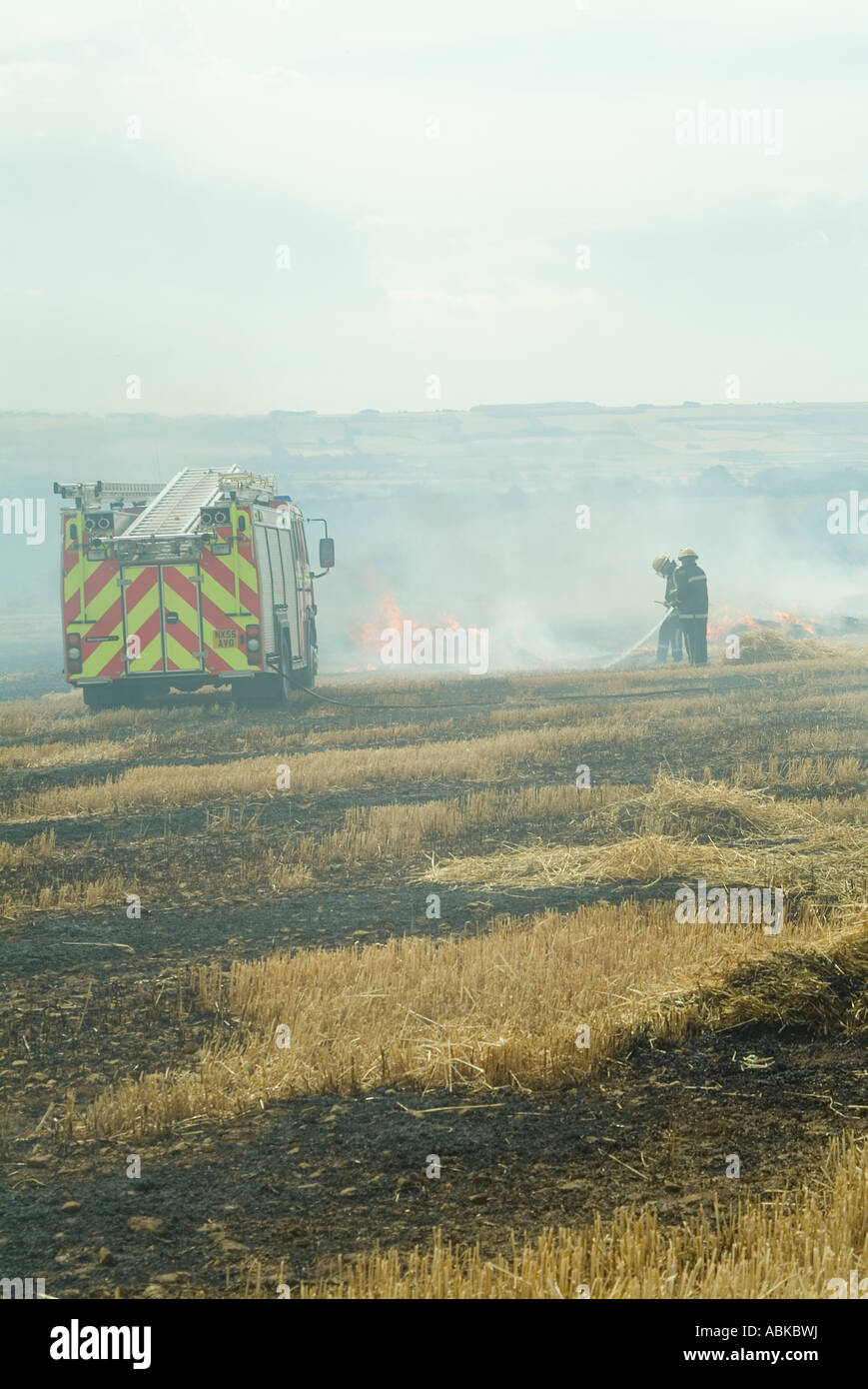 Firemen fighting a field fire on barley stubble in Yorkshire, UK Stock ...