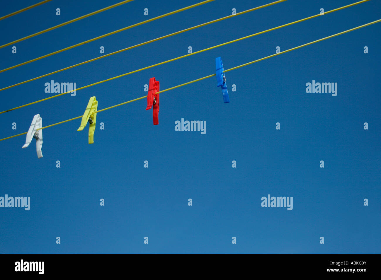 Coloured clothes pegs hanging on washing line Stock Photo - Alamy