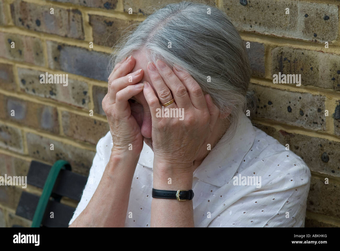 Old woman hiding her face in her hands Stock Photo - Alamy