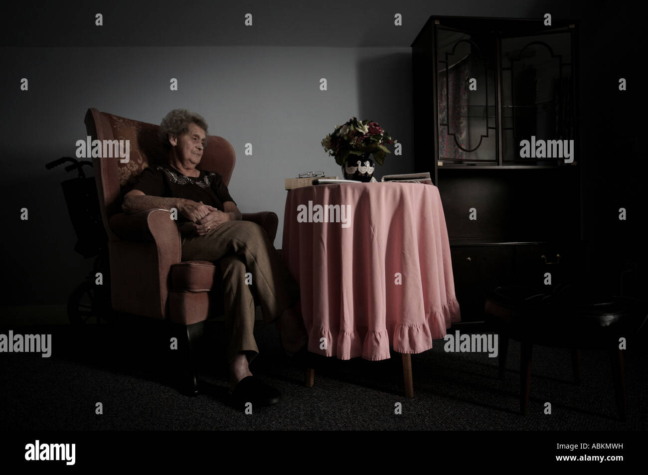 A landscape portrait of an old lady sitting alone in a dark room Stock ...