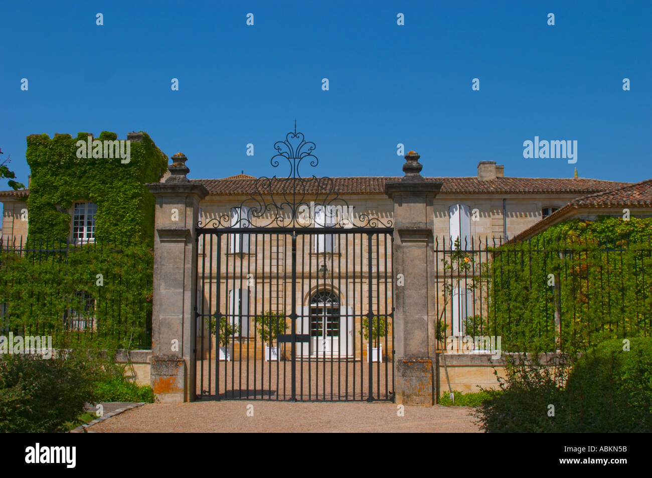 A black iron gate and main chateau building at Chateau Canon Saint ...