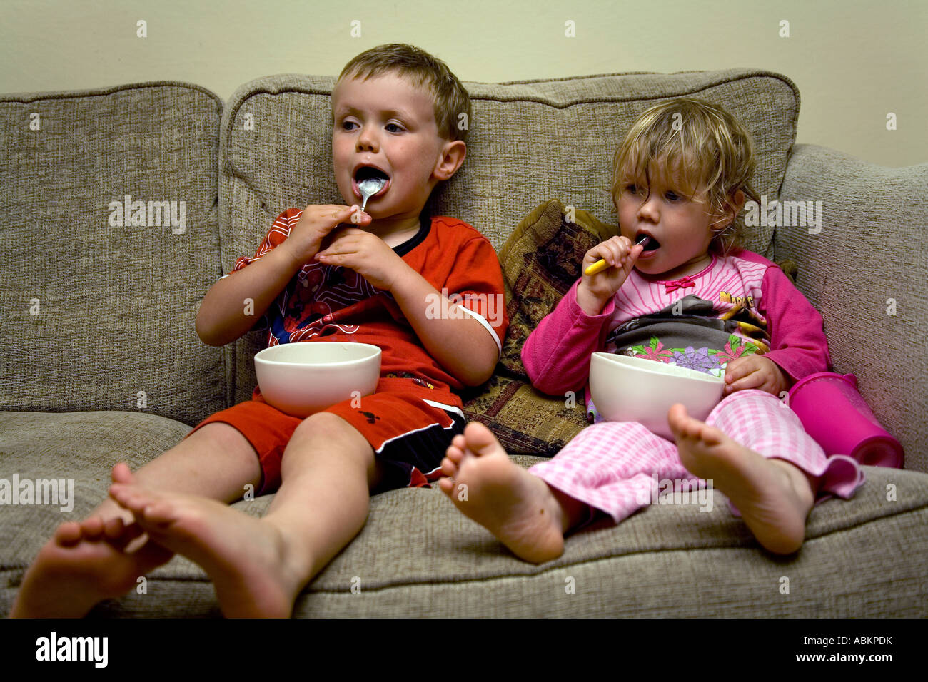 kids on sofa eating Stock Photo - Alamy