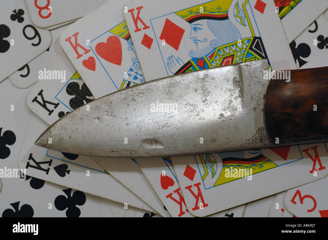 Hand forged knife blade on top of a deck of cards showing a hand of ...