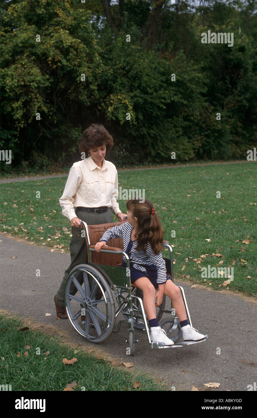 Mother pushes girl in wheelchair Stock Photo - Alamy