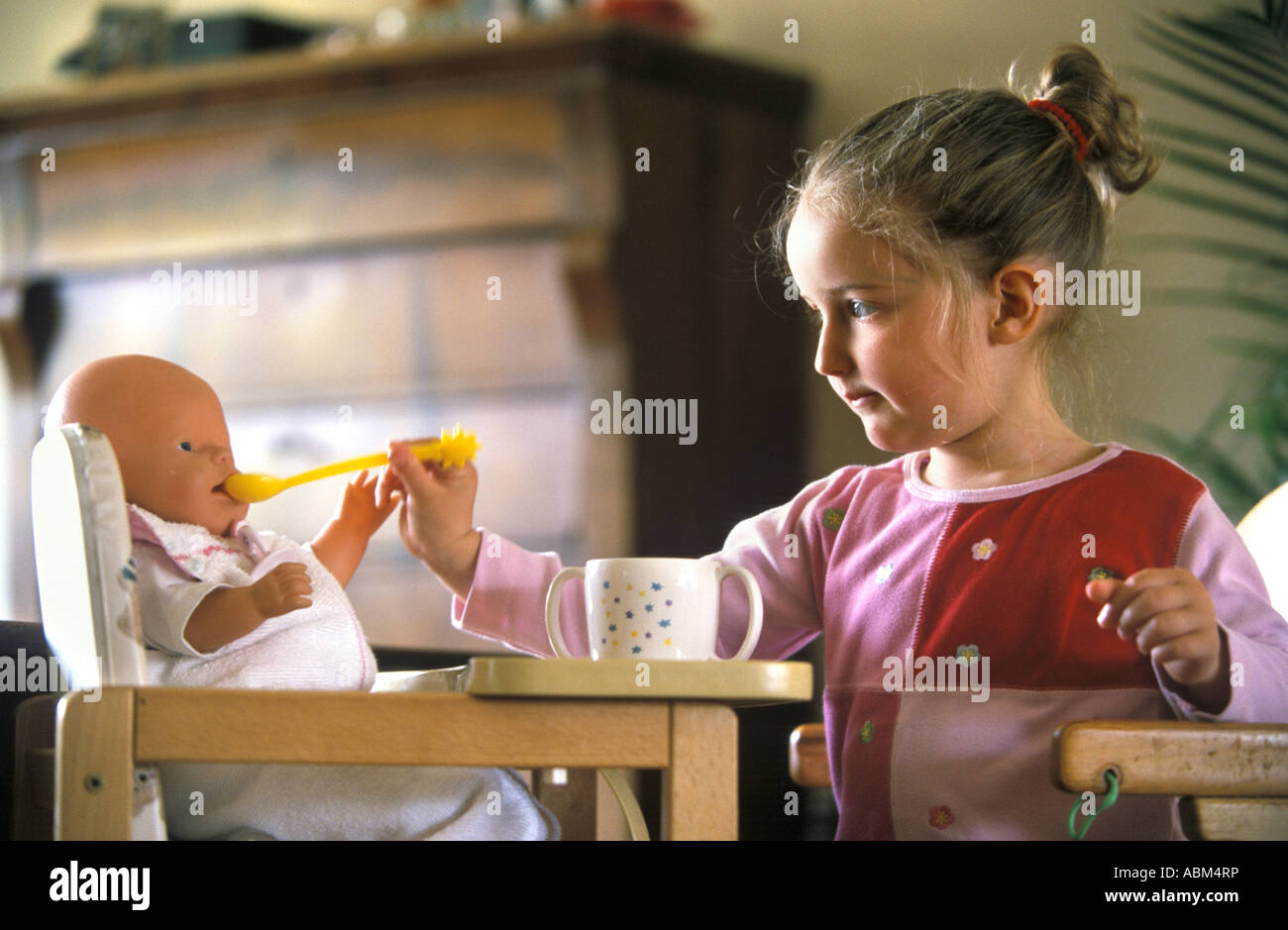Child girl feeding her doll hi-res stock photography and images - Alamy