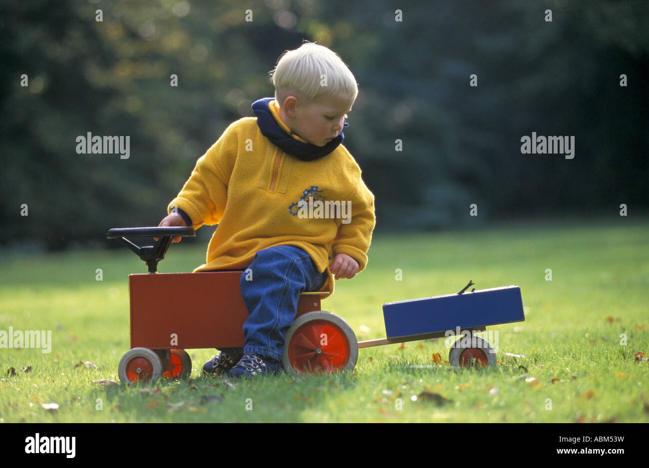Little boy riding with his toy car in the park Stock Photo - Alamy
