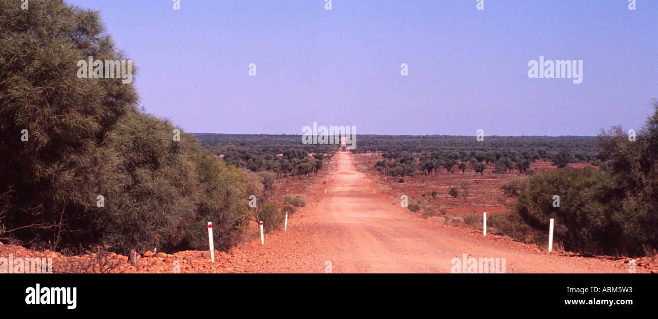 Australian outback road stretching across vast plains cloaked with low ...