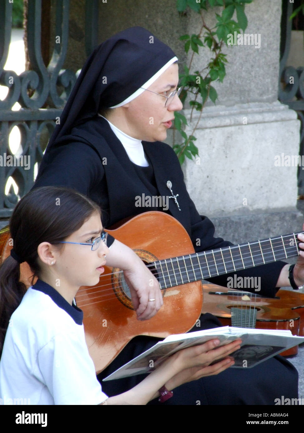 Singing nun playing guitar and young pupil holding music. Madrid Spain ...