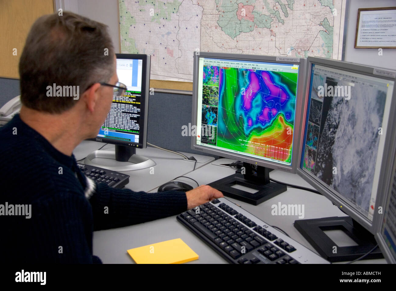 Meteorologist looking at weather maps with satellite data on computer ...