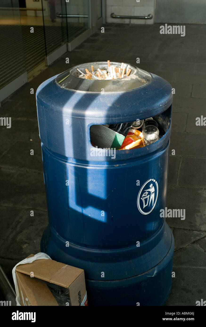 Cigarette filled ashtray on top of litter bin outside shopping centre ...