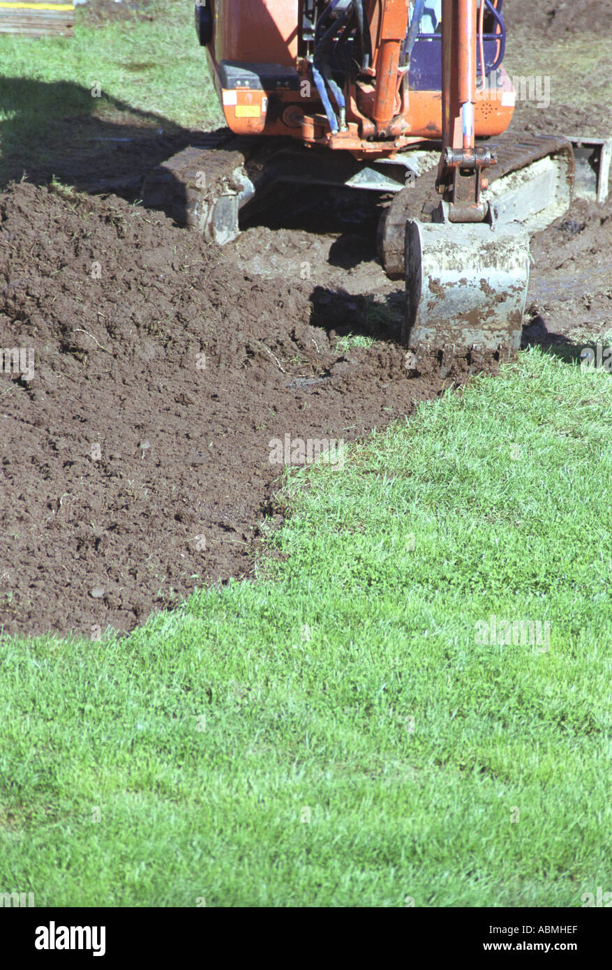 mechanical digger digging hole in field Stock Photo - Alamy