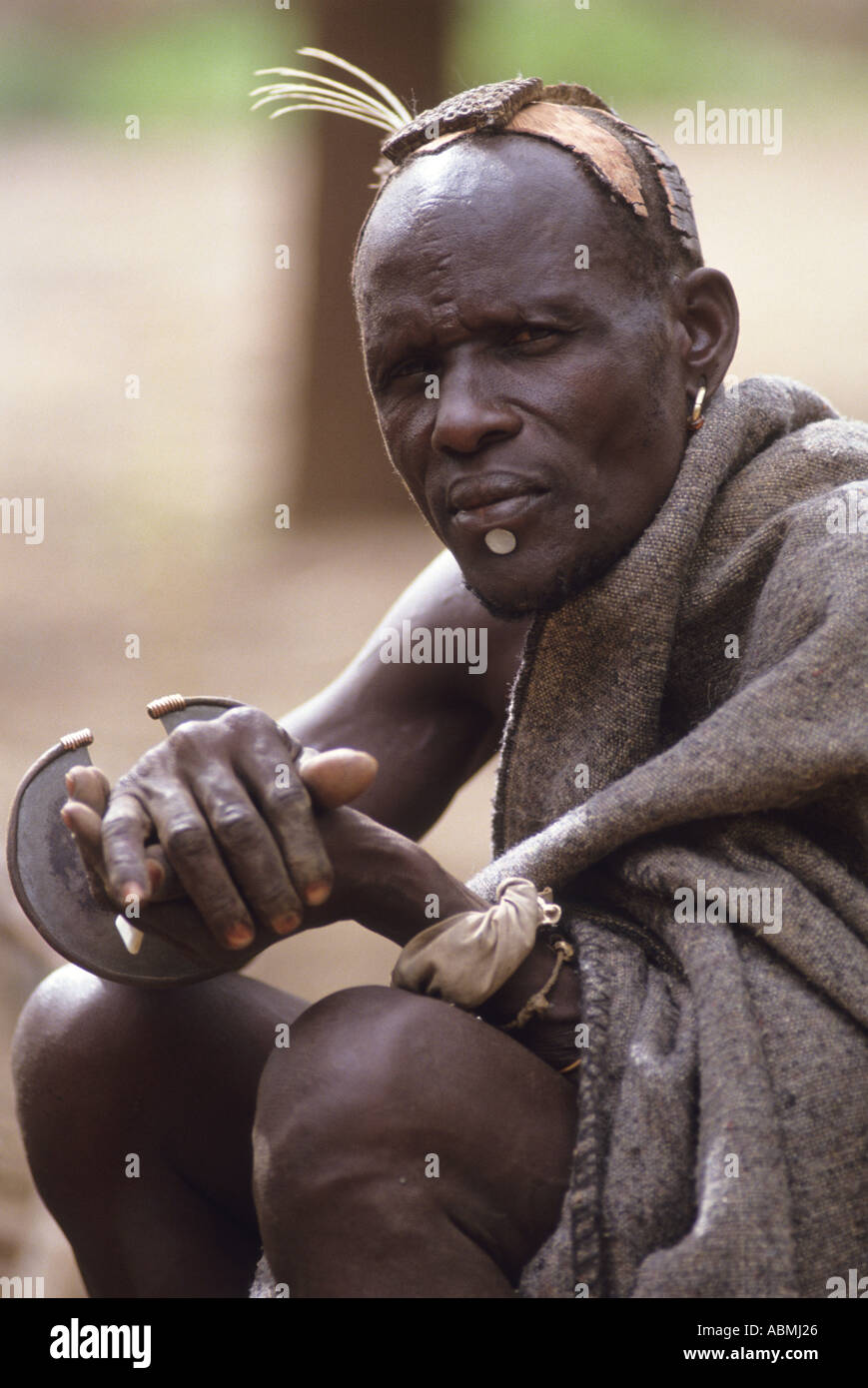 A Turkana man and traditional headress On his wrist is a circular knife ...