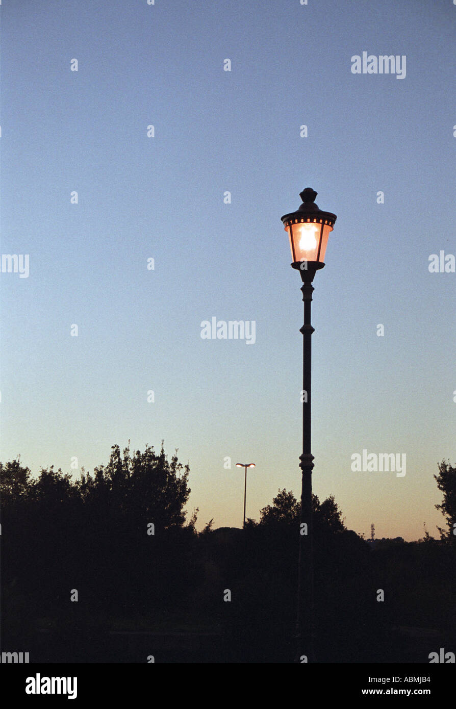 old fashioned lamp post lit at night with trees Stock Photo - Alamy