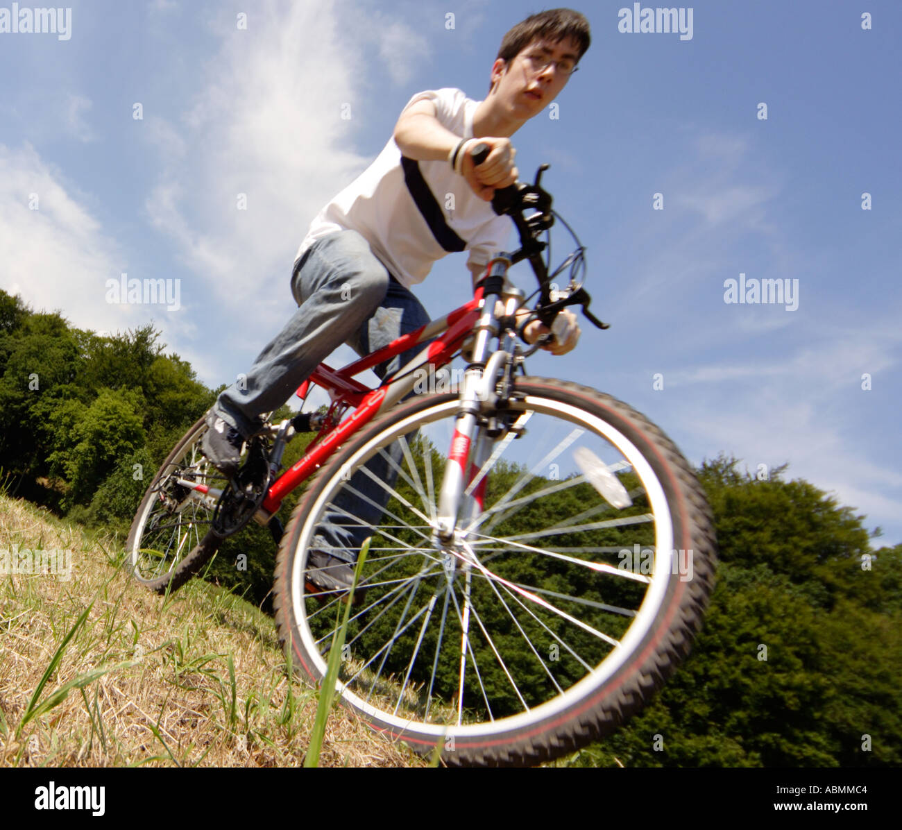 Low wide angle shot of a boy aged 14 riding a bike Stock Photo - Alamy