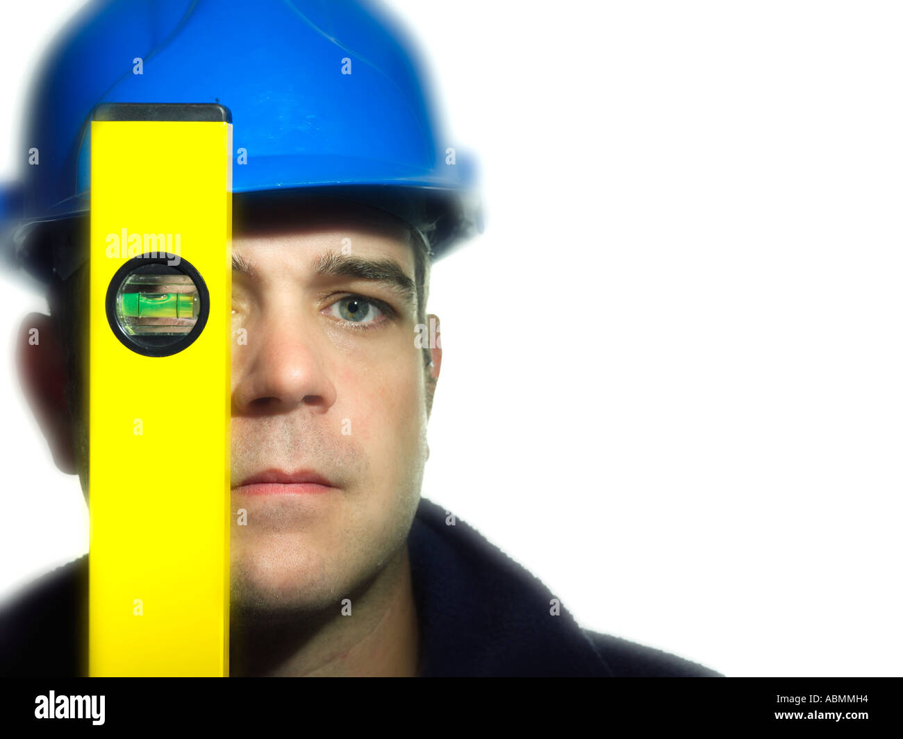 a builder in safety hard hat holding a spirit level Stock Photo - Alamy