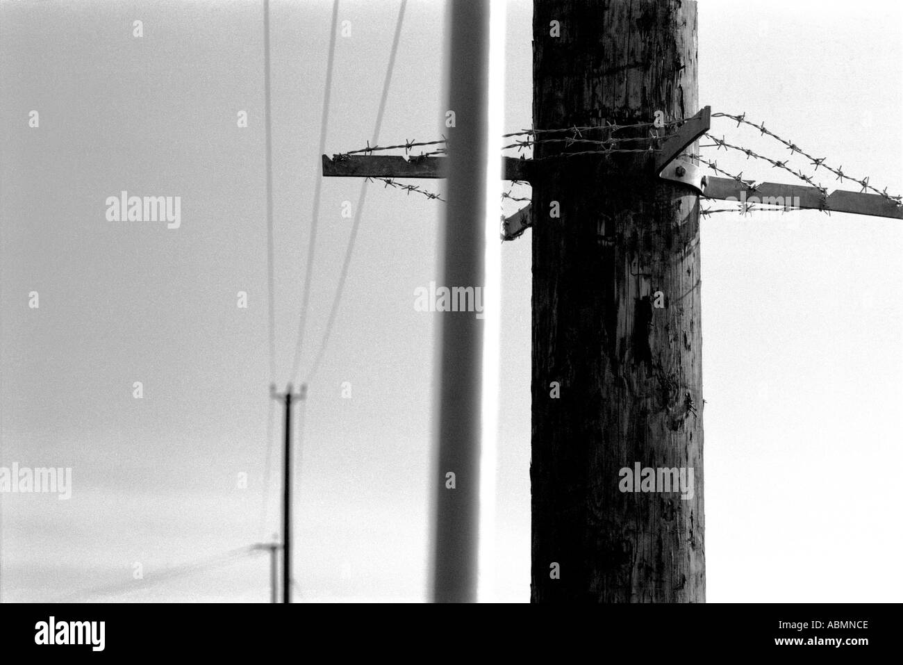 A telephone pylon surrounded by barbed wire Stock Photo - Alamy