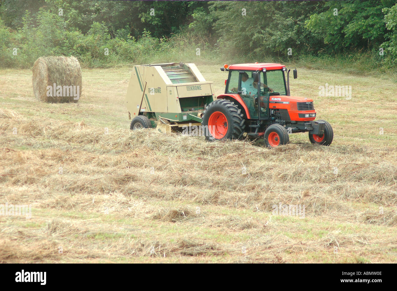 tractor working on farm Cutting and rolling hay for bailing in squares ...