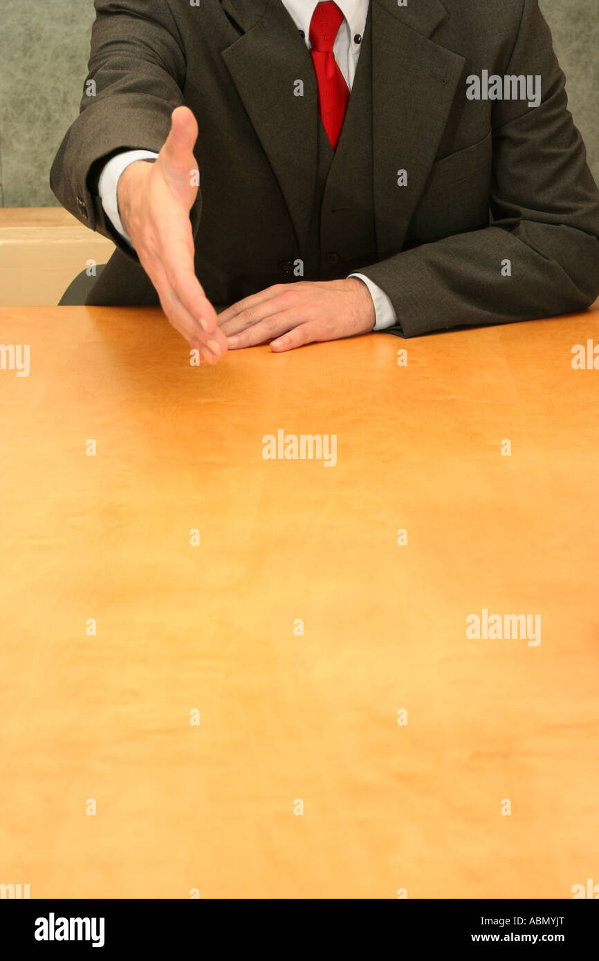 Business man sitting at the desk wanting to shake your hand Stock Photo ...