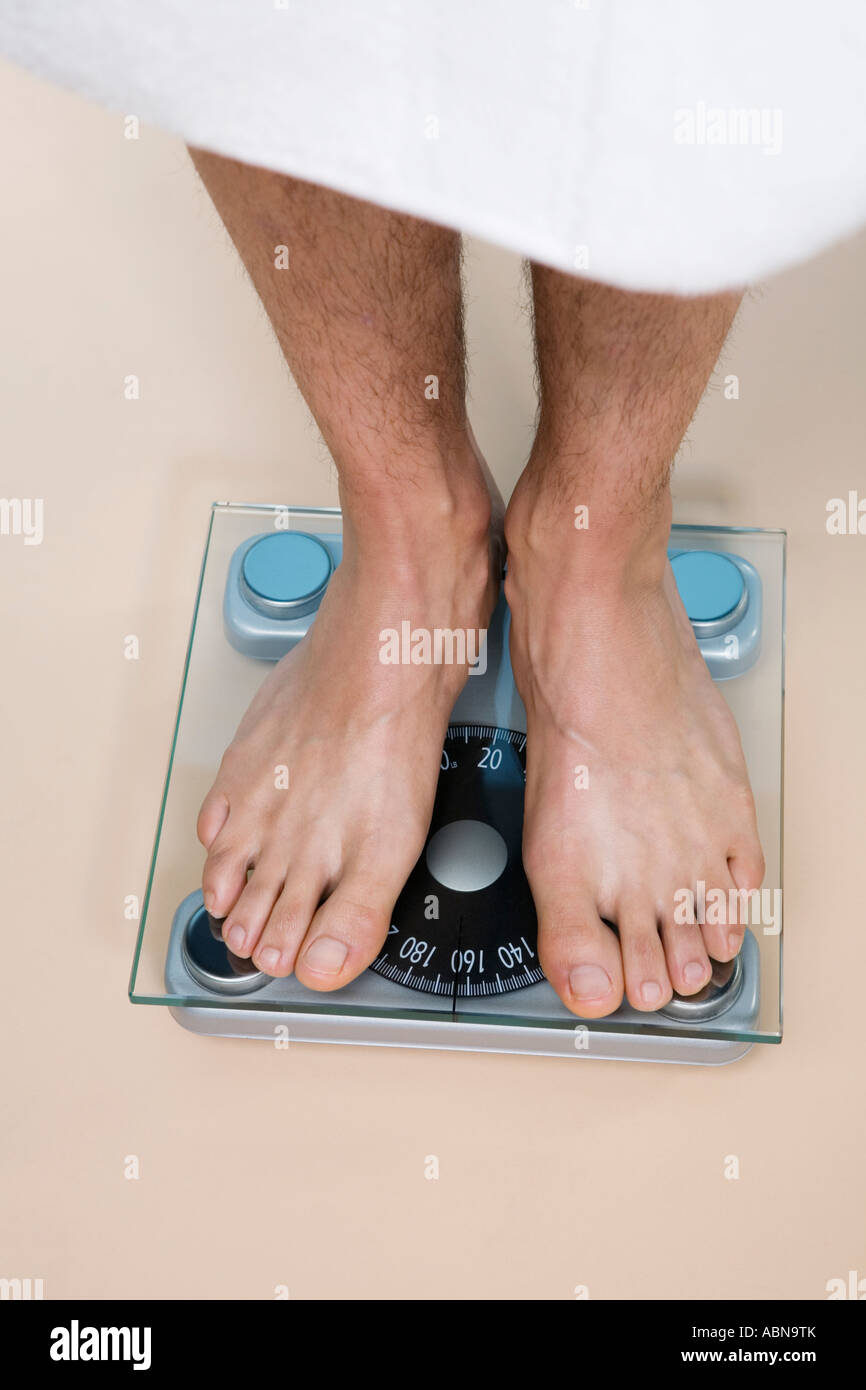 Man weighing himself Stock Photo - Alamy