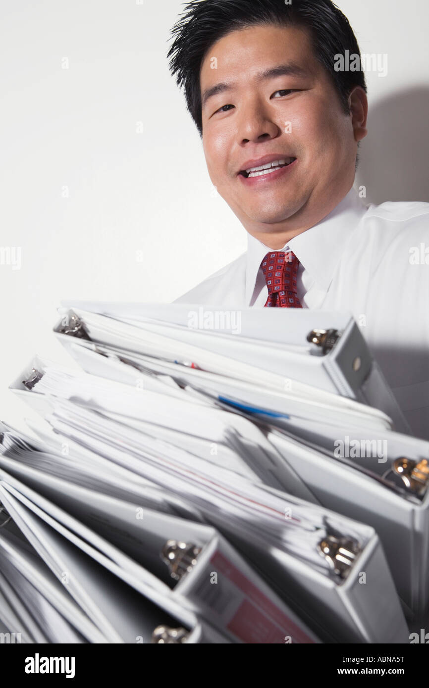 Businessman carrying stack of binders Stock Photo - Alamy