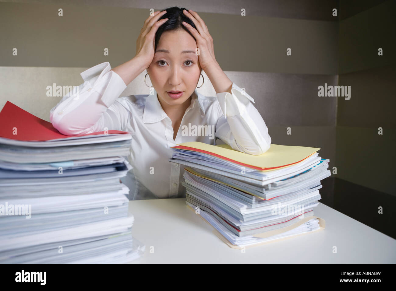 Businesswoman leaning on large piles of work Stock Photo - Alamy