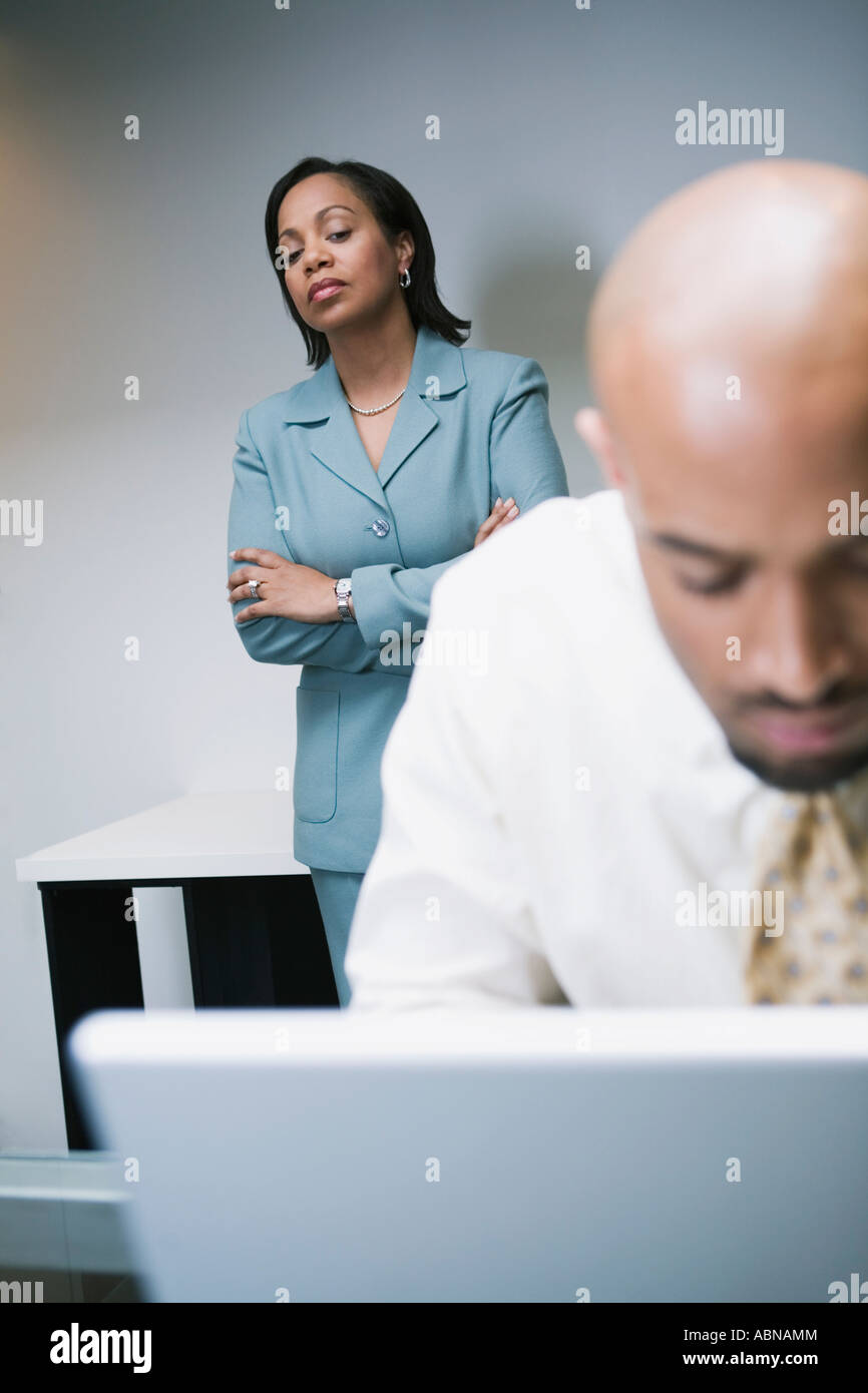 Businesswoman supervising male colleague’s work Stock Photo - Alamy