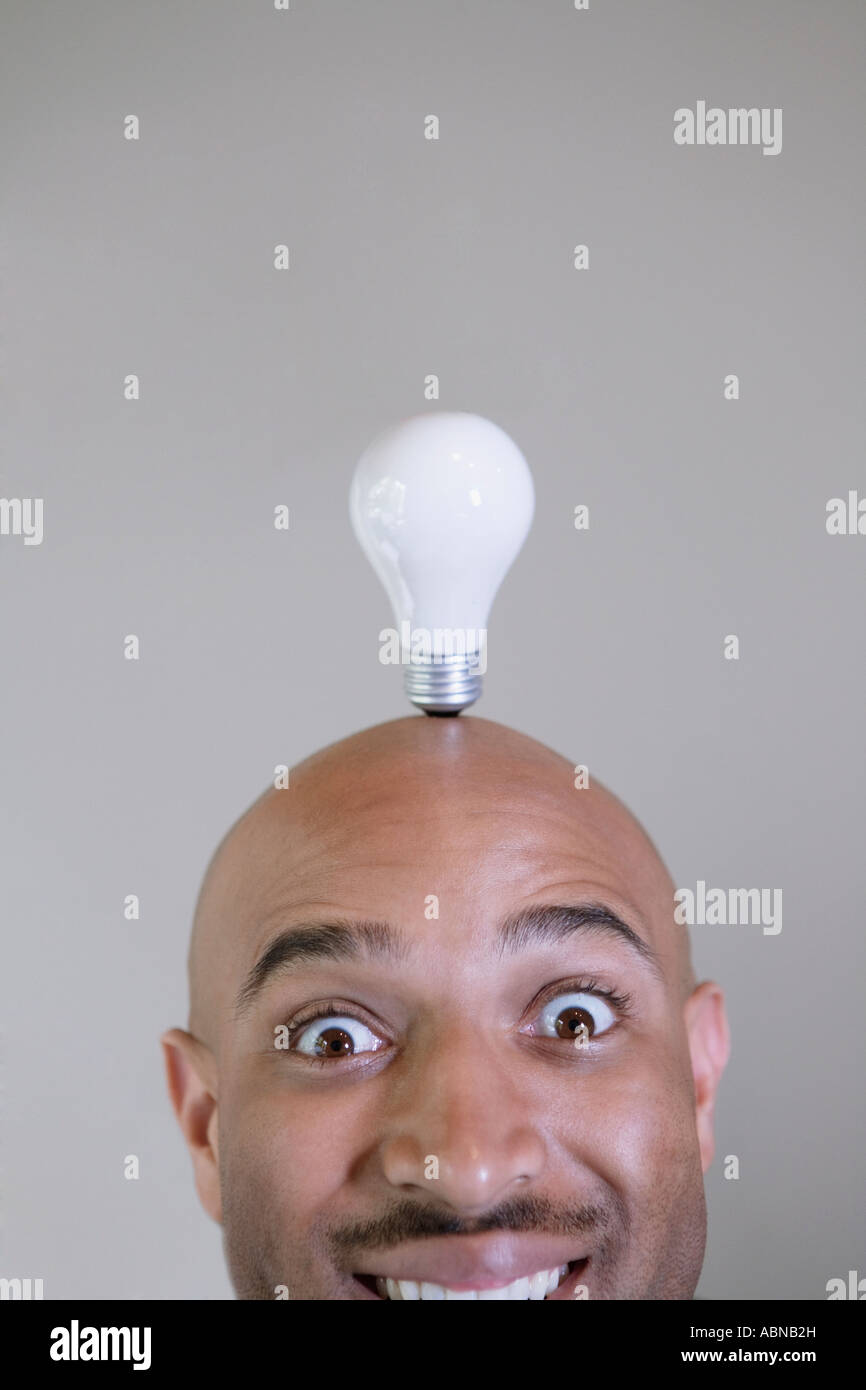 Businessman balancing a light bulb on head Stock Photo - Alamy