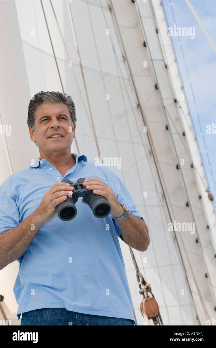 Man using binoculars on ship deck Stock Photo - Alamy