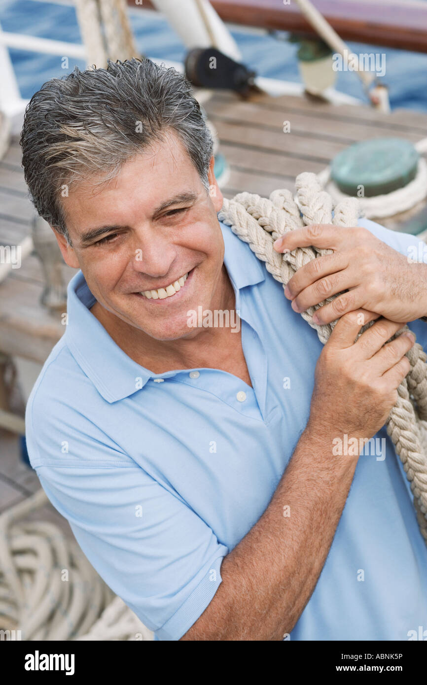 Man carrying rigging on ship deck Stock Photo - Alamy