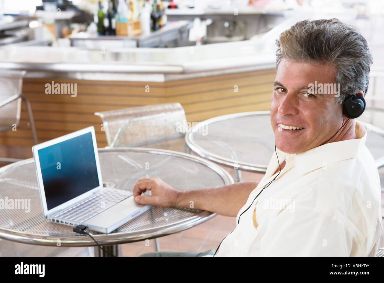 Man using headphones with laptop in restaurant Stock Photo - Alamy