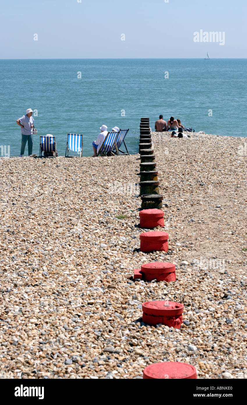 Red painted breakwater bollards on pebble beach Eastbourne Stock Photo ...
