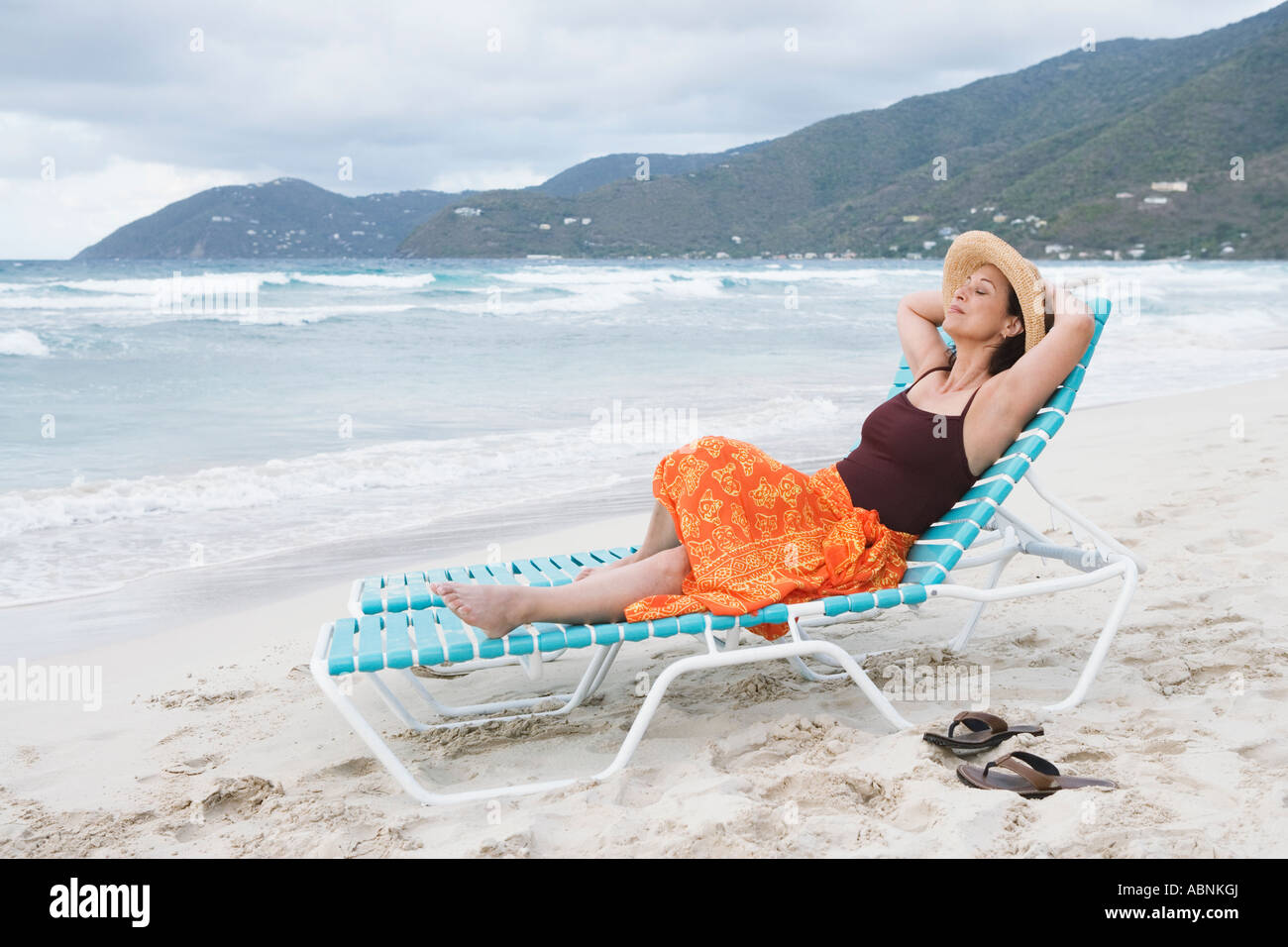 Woman sunbathing on cloudy beach Stock Photo - Alamy