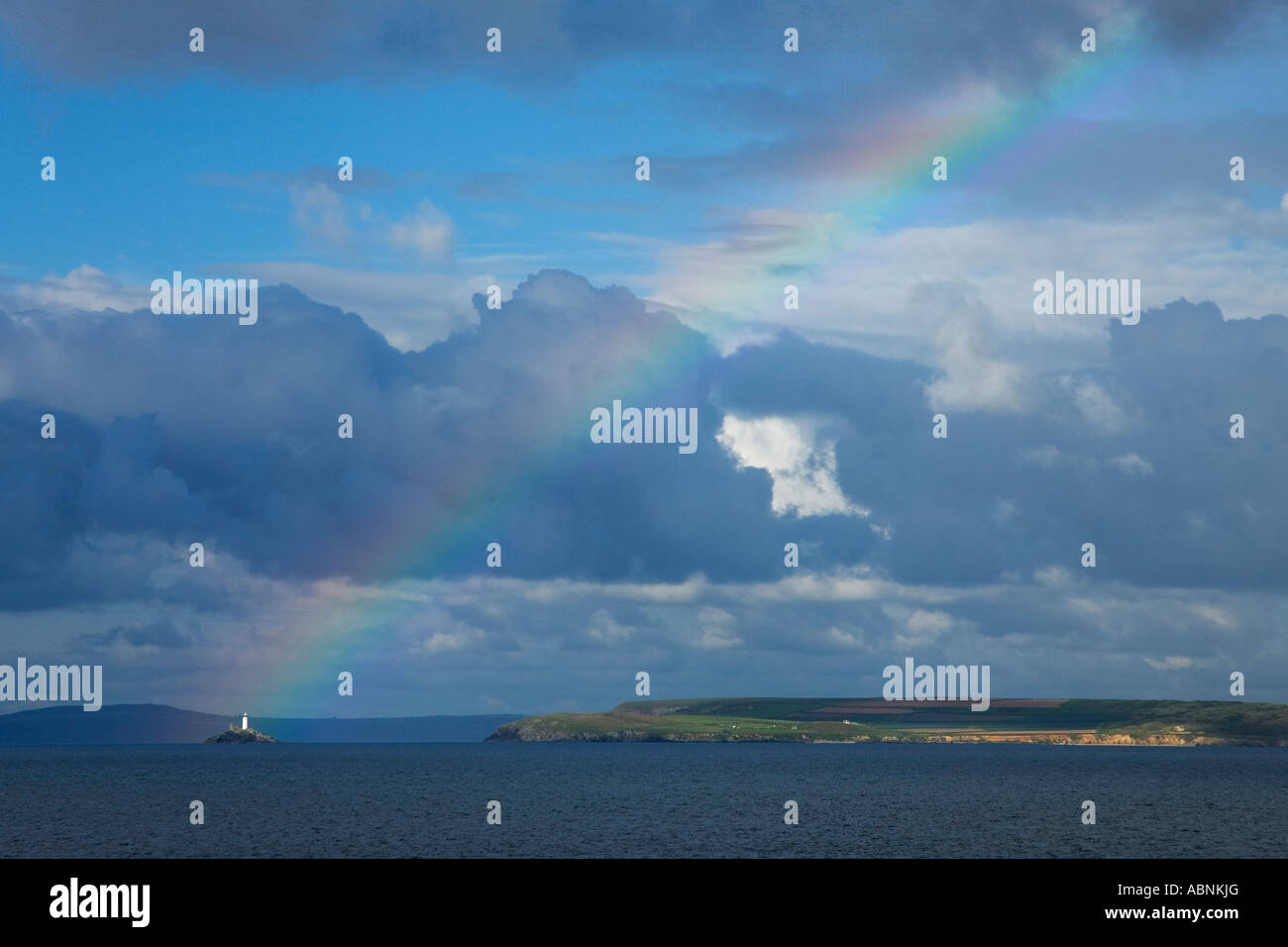 Rainbow over Godrevy lighthouse with blue sea and white clouds in sky ...