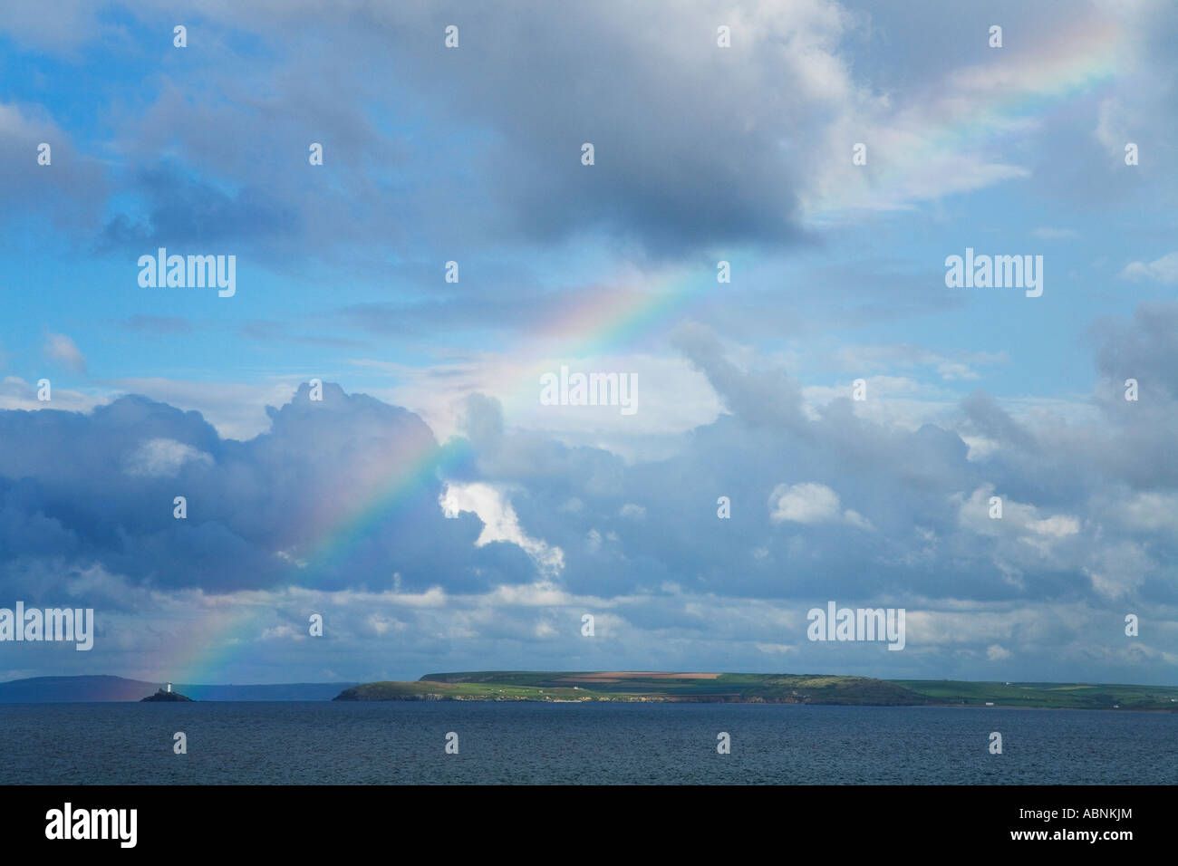 Rainbow over Godrevy lighthouse with blue sea and white clouds in sky ...