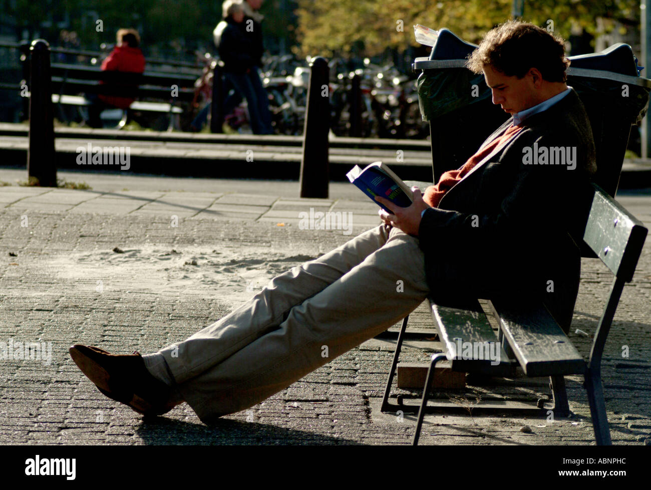 young man sitting reading a book Stock Photo - Alamy