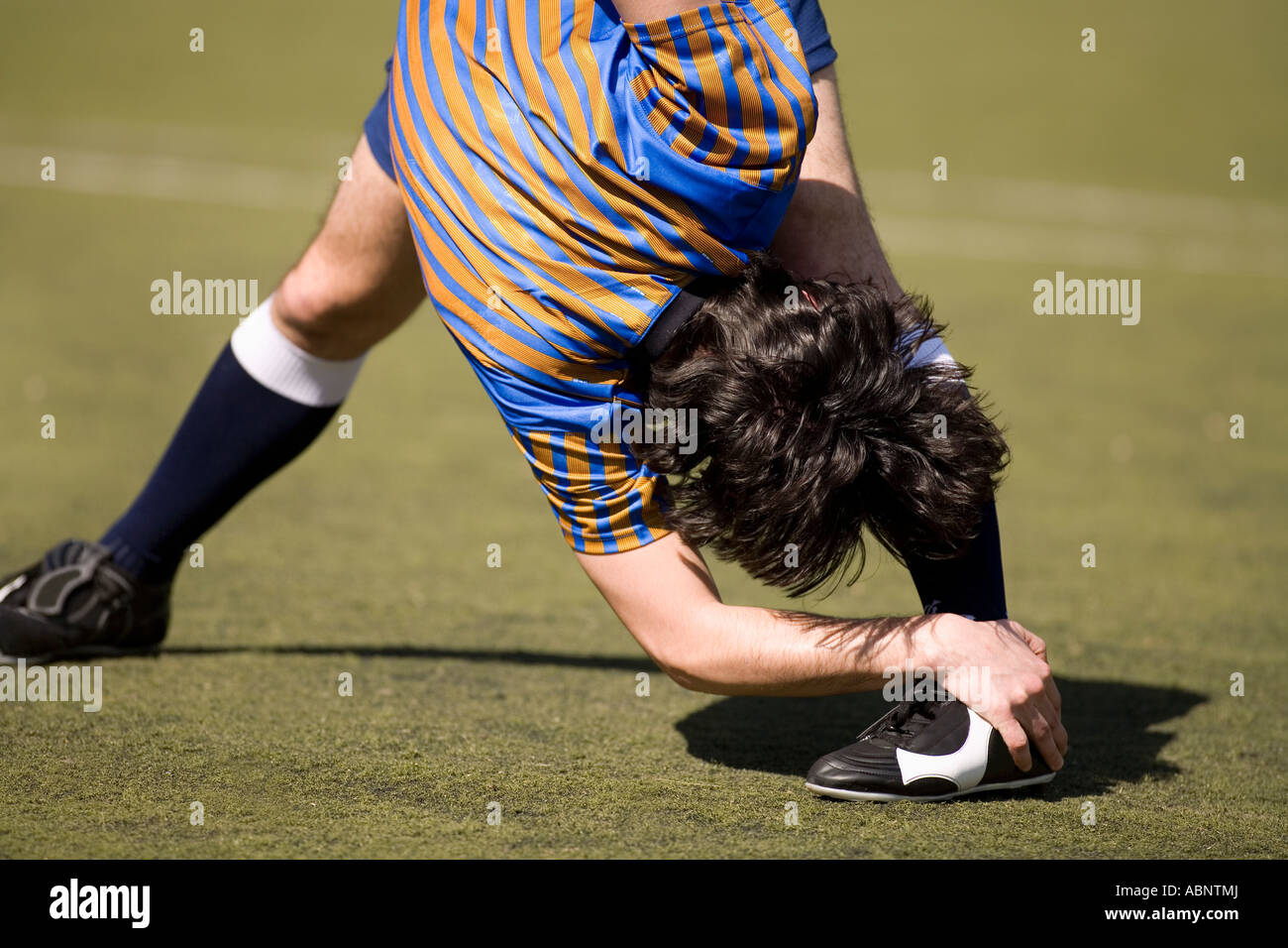 Soccer player stretching on field Stock Photo - Alamy