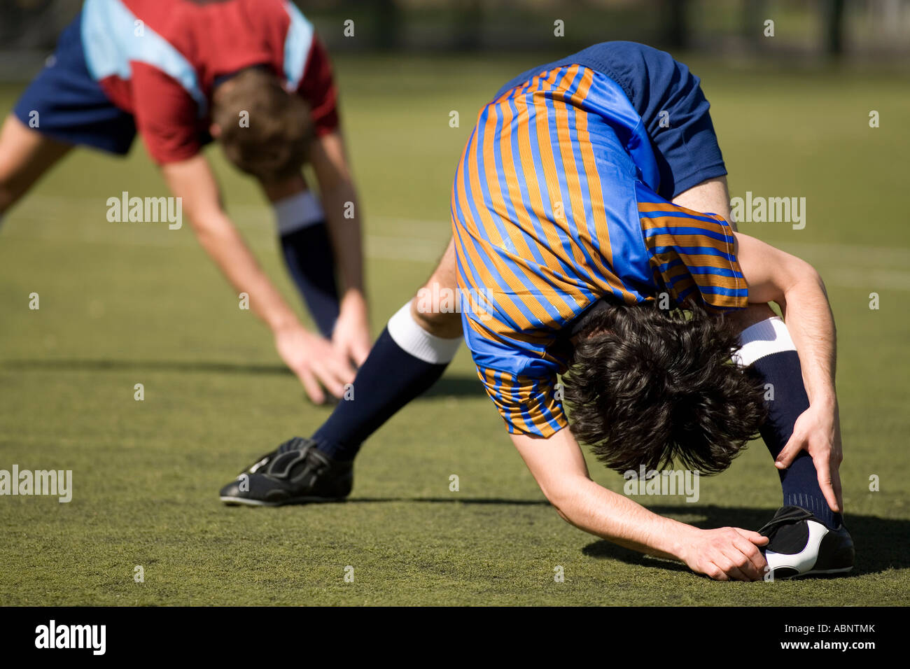 Soccer player stretching on field Stock Photo - Alamy