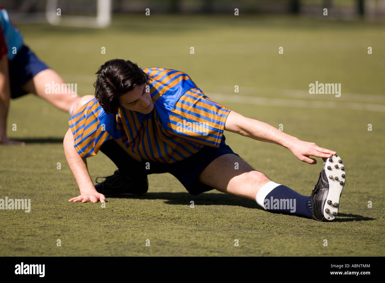 Soccer player stretching on field Stock Photo - Alamy