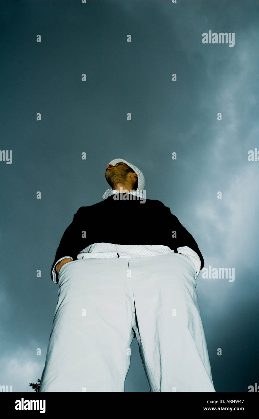 A young man looking at the sky and thinking. Dark, cloudy sky in the ...