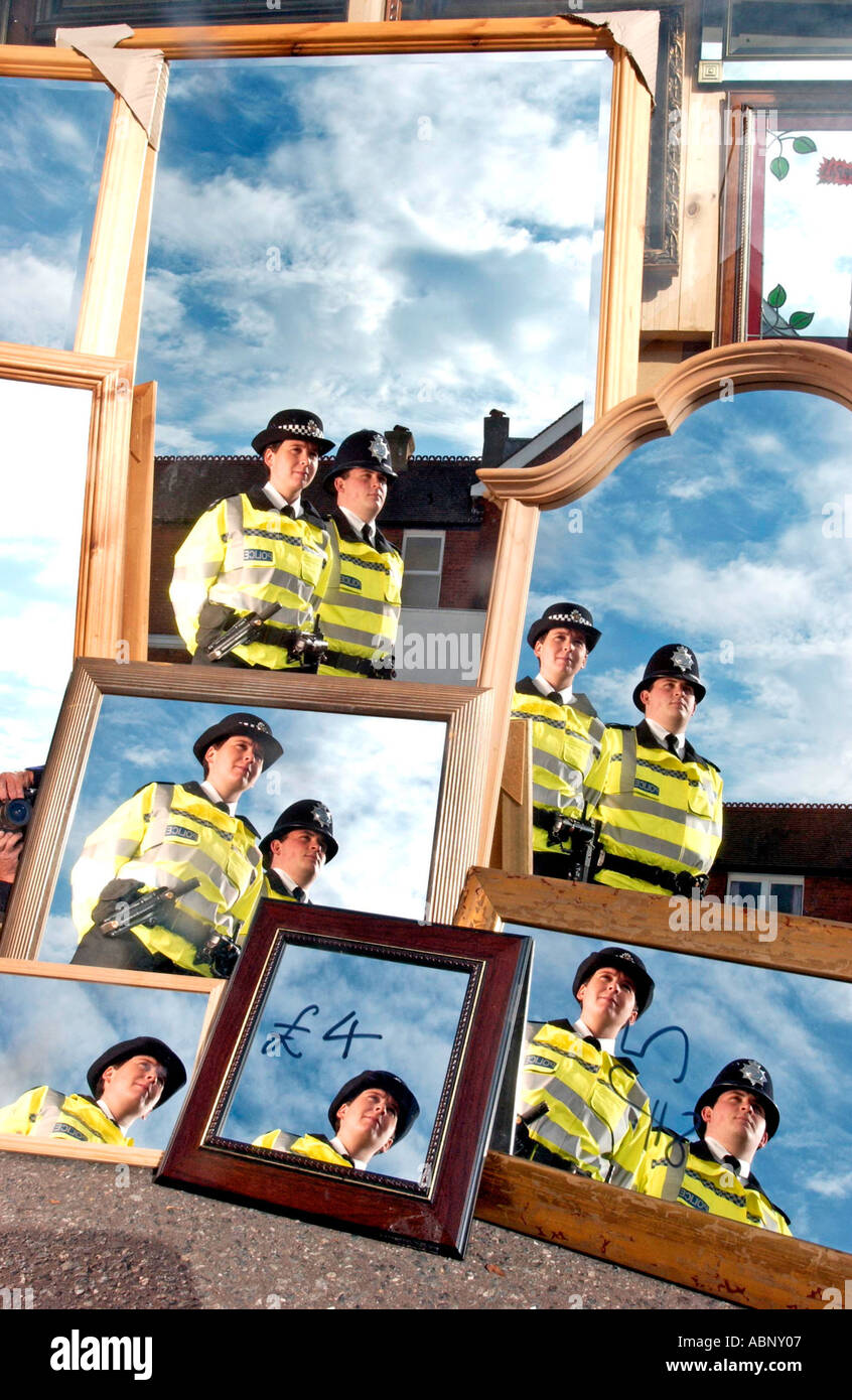 two police officers reflected in mirrors in shop window in Sussex Stock ...