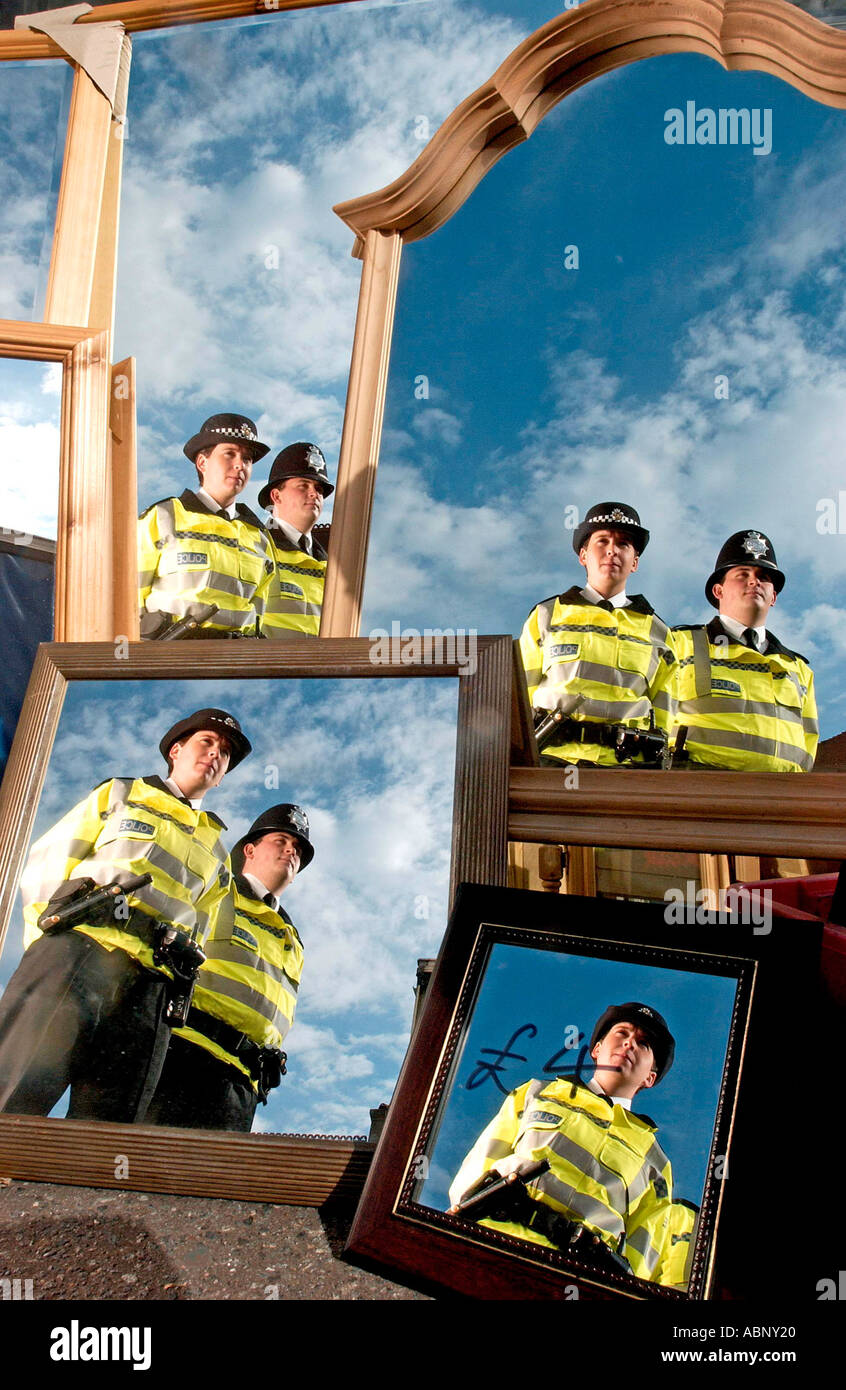two police officers reflected in mirrors in shop window in Sussex Stock ...