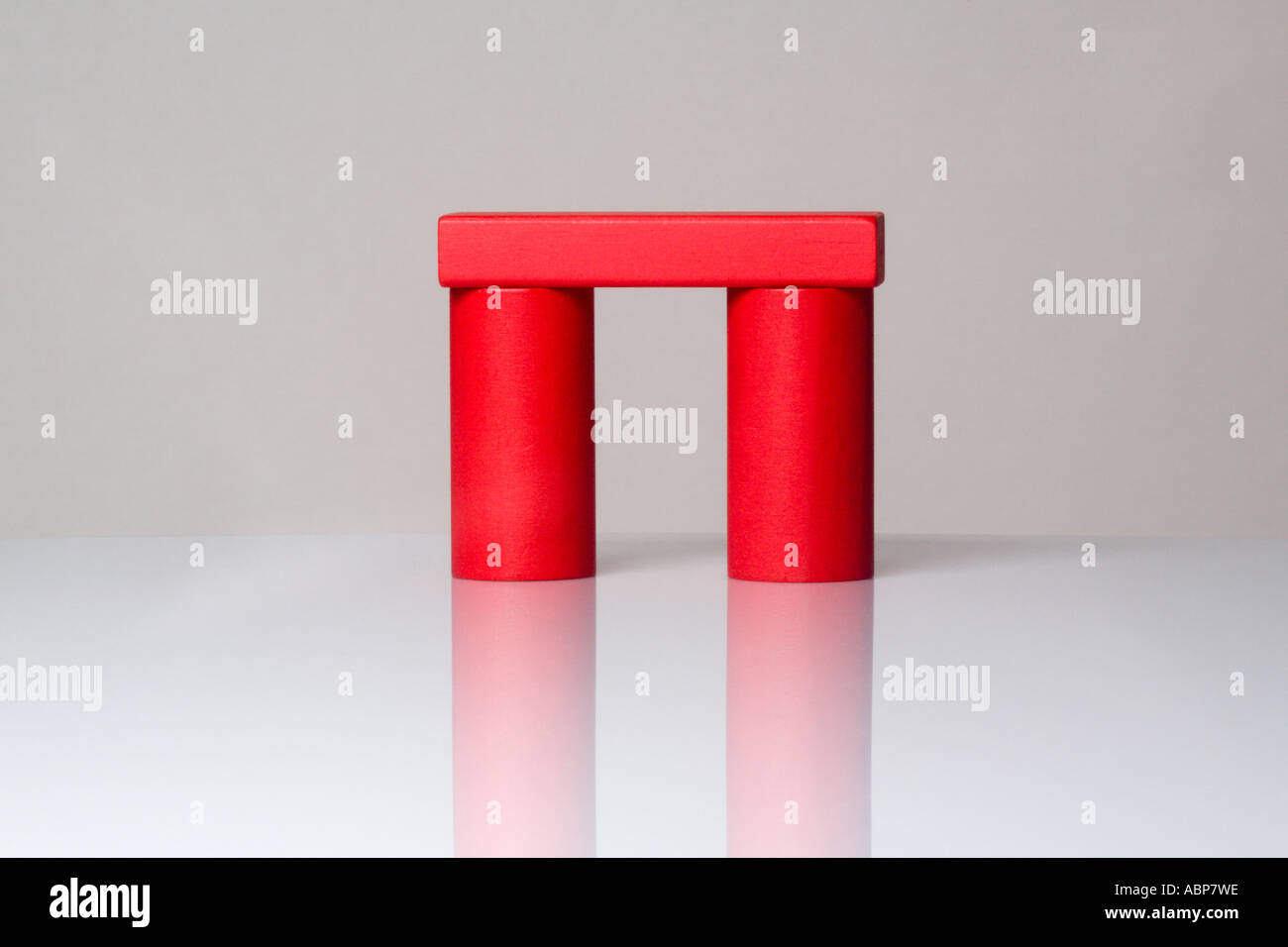 3 red wooden blocks on a white back ground in a shape off a bridge ...
