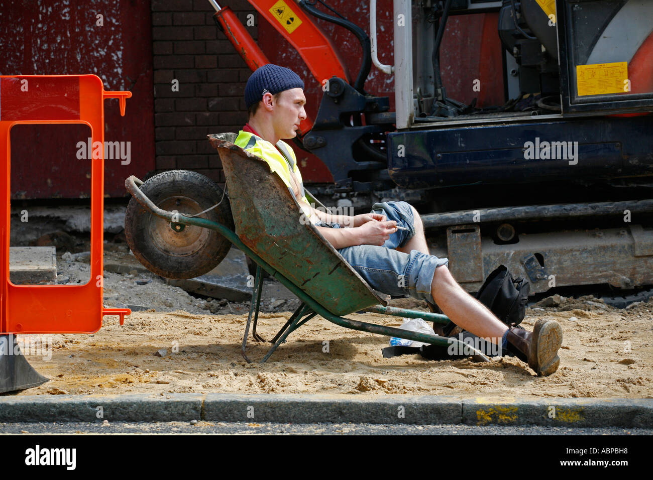 British Worker having a break from his job by resting in a wheelbarrow ...