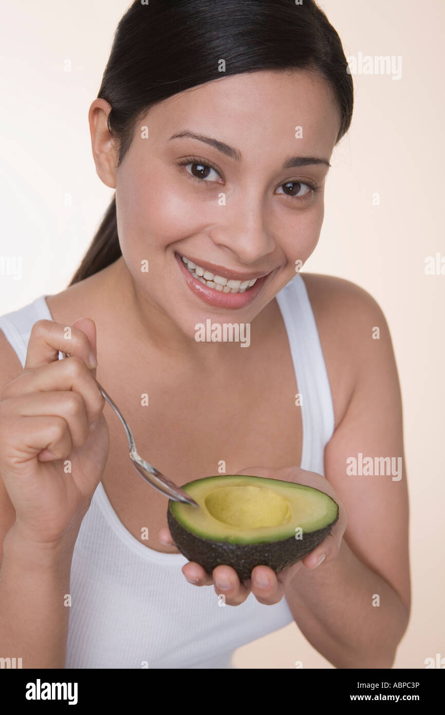 Woman eating avocado Stock Photo - Alamy