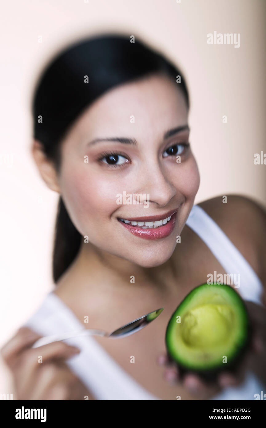Woman eating avocado Stock Photo - Alamy