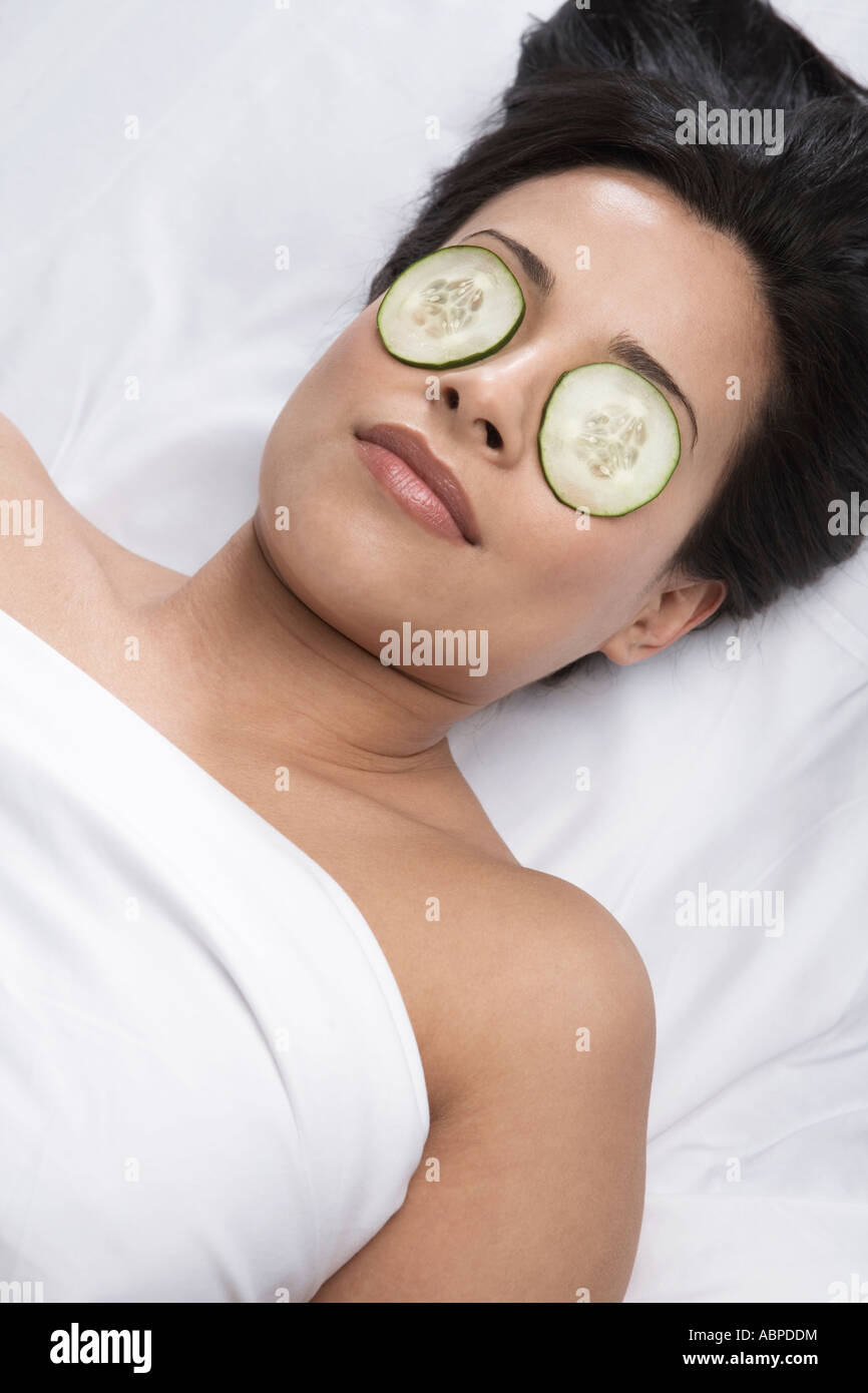 Woman wearing cucumbers on eyes Stock Photo - Alamy