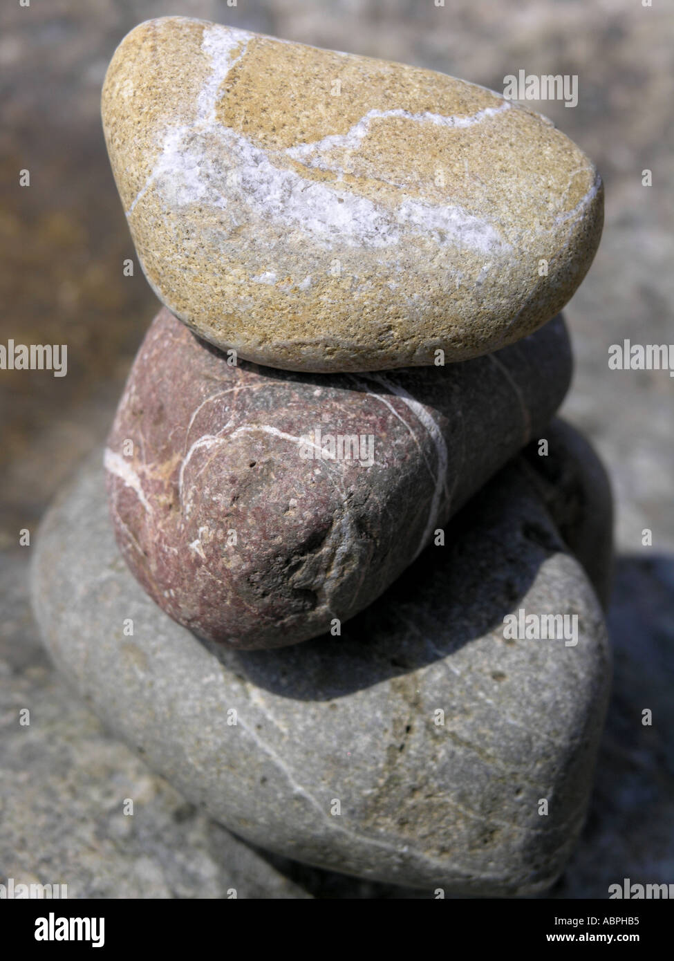 Three coloured pebbles in a stack Stock Photo - Alamy