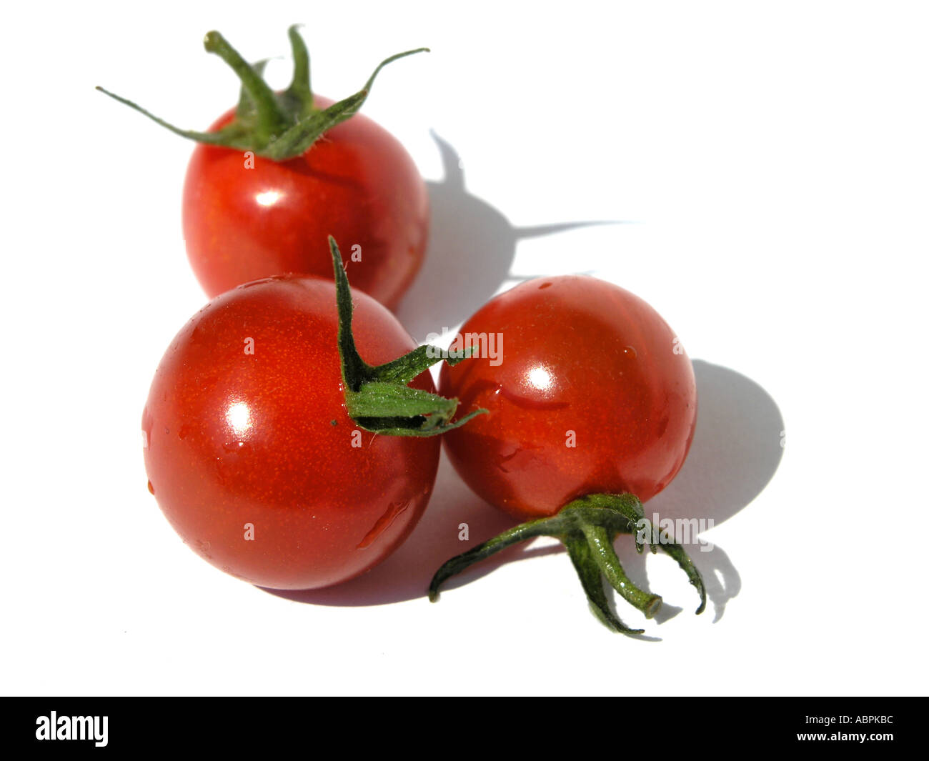 Three cherry tomatoes against white background Stock Photo - Alamy