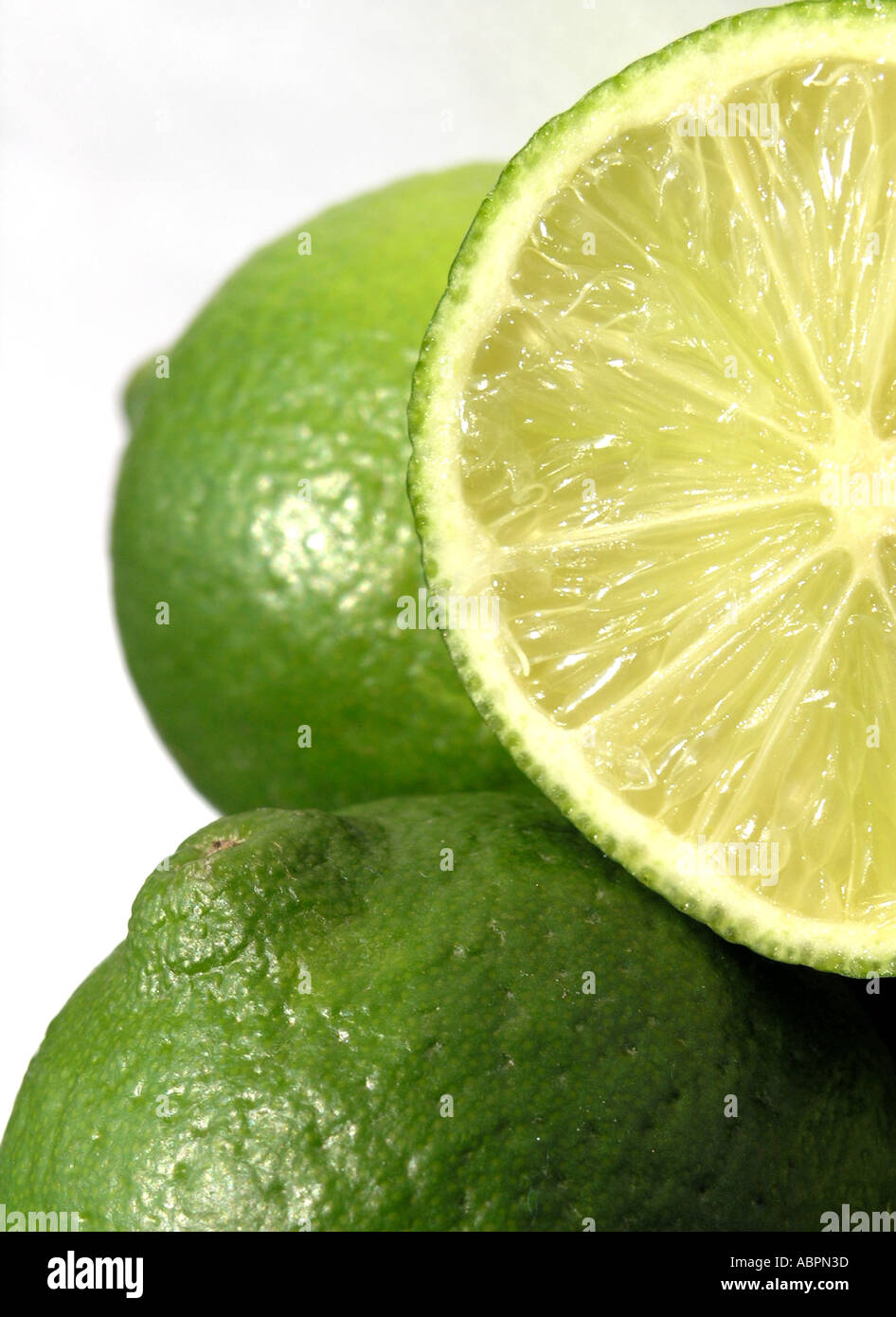 Whole fresh limes with one lime cut in half Stock Photo - Alamy